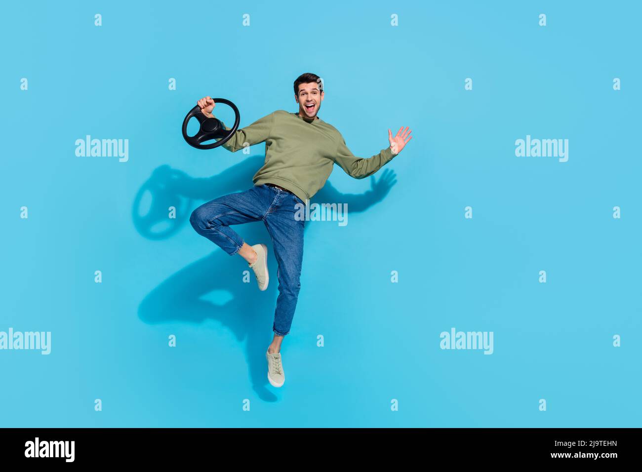 Full length photo of impressed young brunet guy drive car jump wear ...