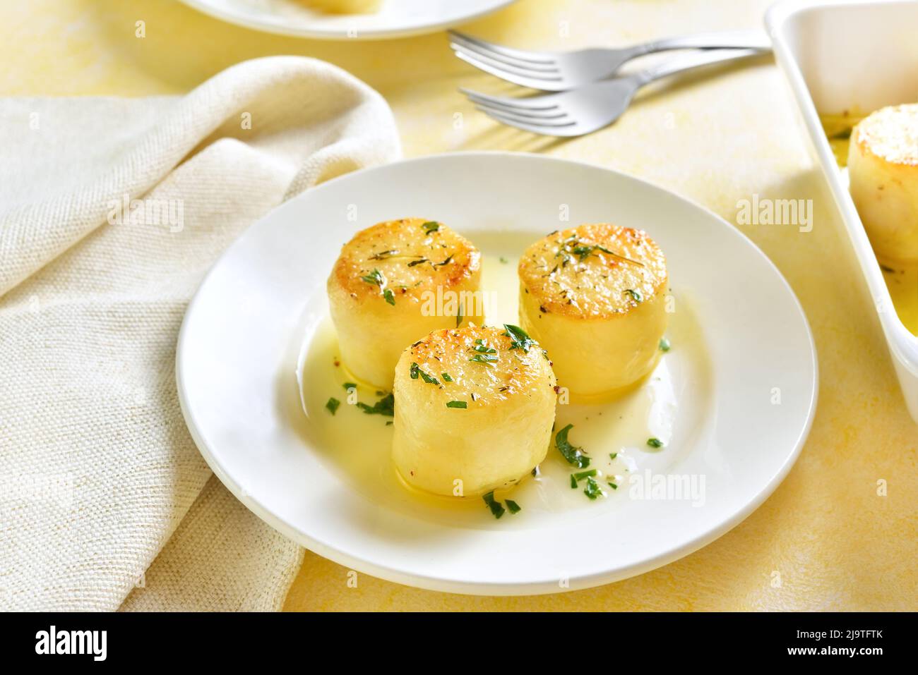 Fondant potatoes on plate over light background. Close up view Stock ...