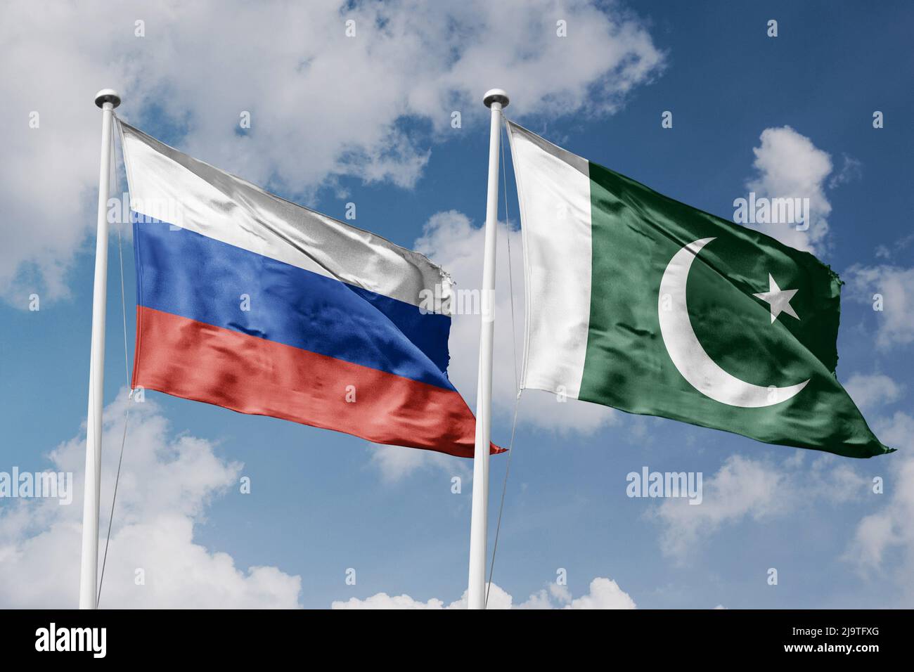 Russia and Pakistan two flags on flagpoles and blue cloudy sky ...