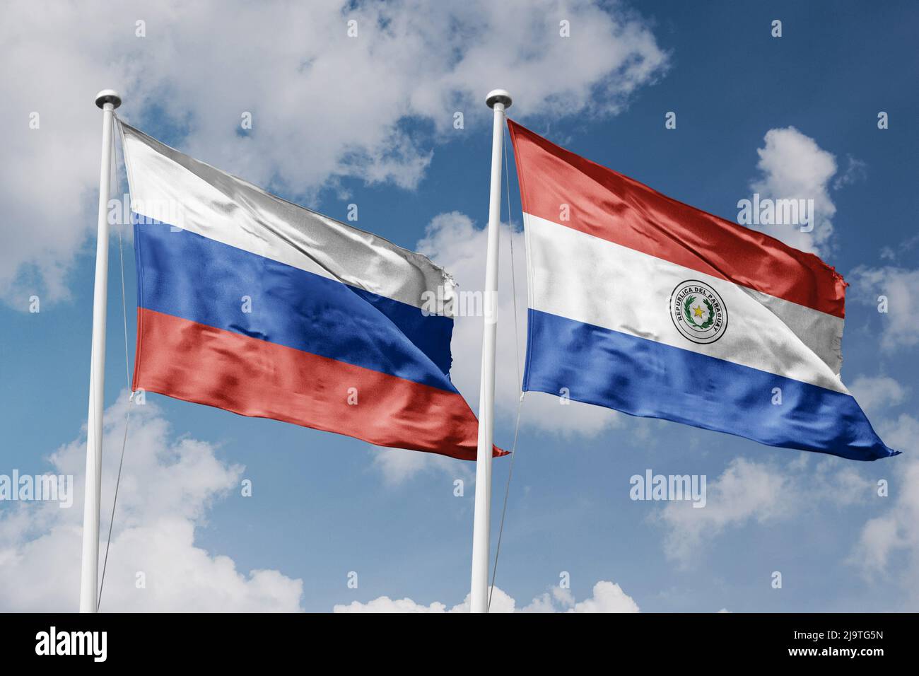 Russia and Paraguay two flags on flagpoles and blue cloudy sky ...