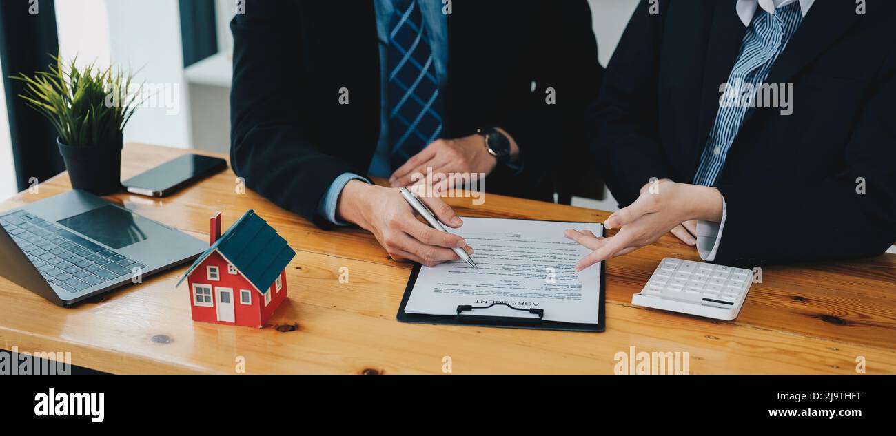 Experienced real estate agent showing house model to client and ready ...