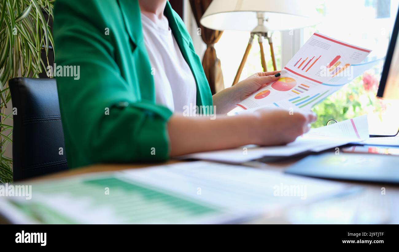 Businesswoman studies analytical business charts in office Stock Photo ...
