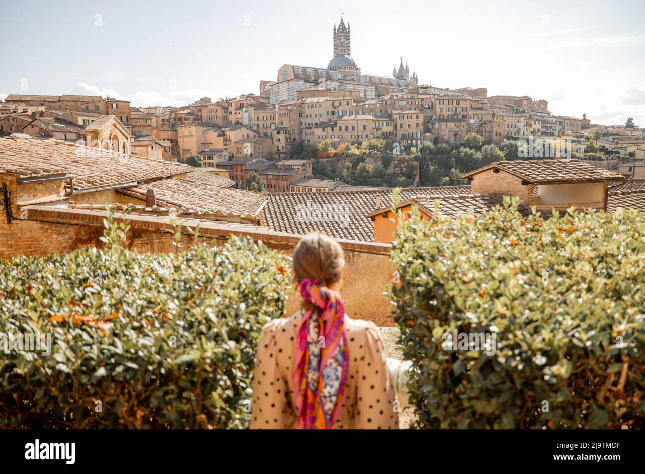 woman walks on background of cityscape of Siena old town in Italy Stock ...