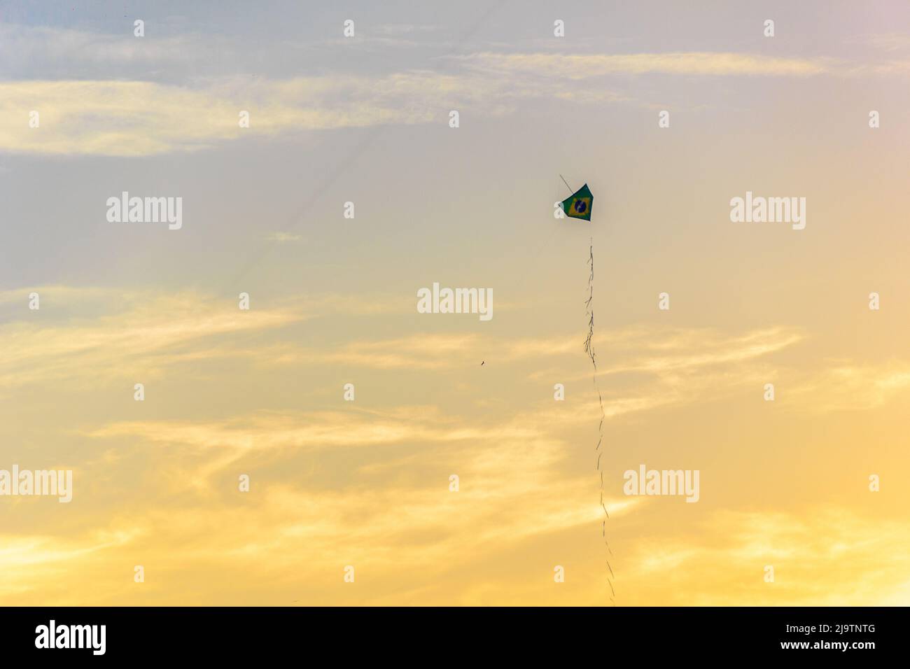 kite with the flag of Brazil in a beautiful yellow sky in the late ...