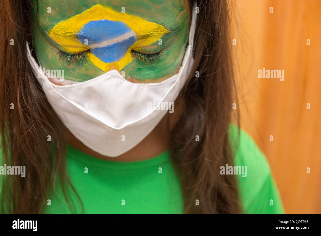 child with a mask with his face painted with the flag of Brazil Stock ...