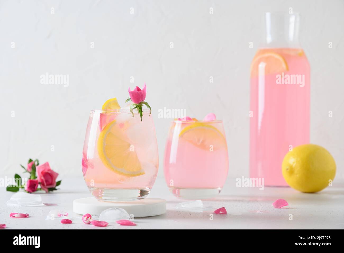 Pink rose cocktails, drinks or lemonade with rose flowers and lemon on ...