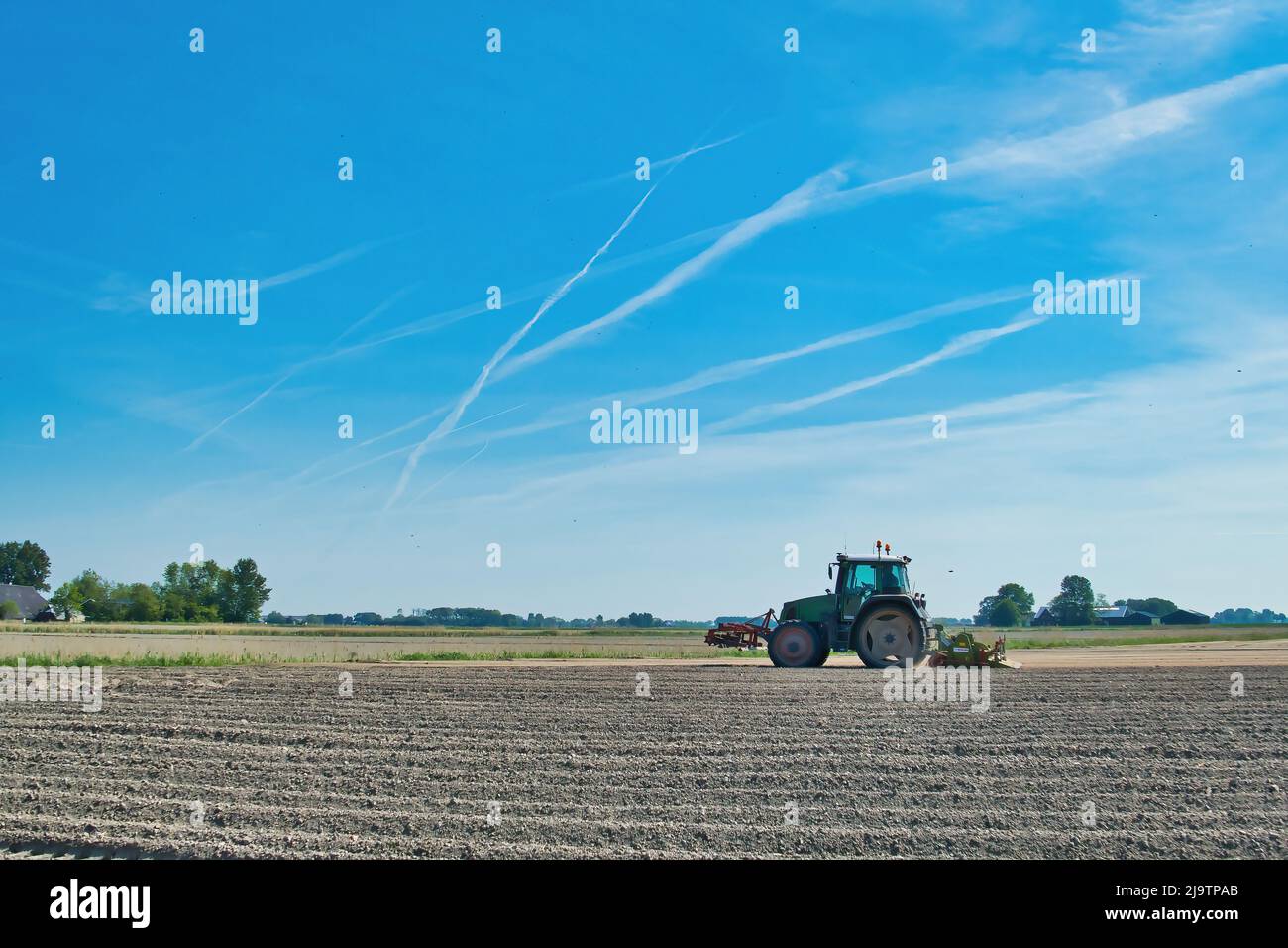 Harrowing a ploughed field in the Dutch province of Groningen. Tractor ...