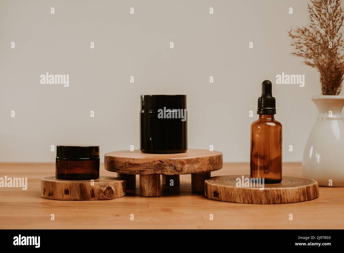 Cosmetics container set on wooden desk and grey beige natural ...