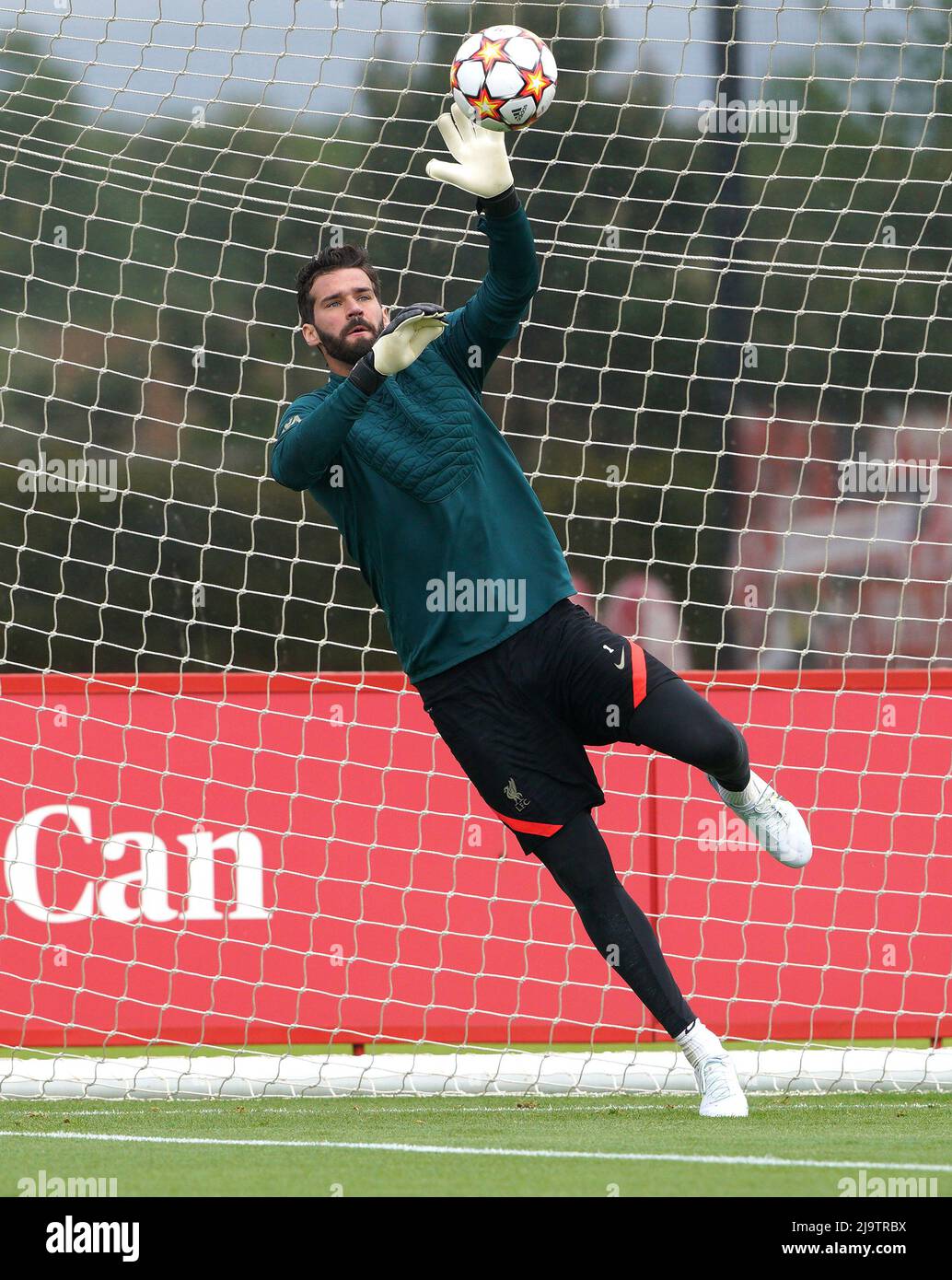 Liverpool goalkeeper Alisson makes a save during a media day at the AXA ...