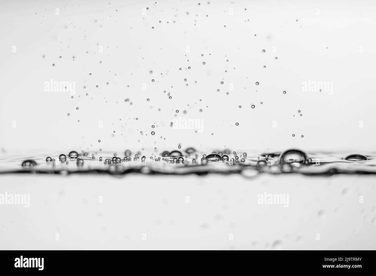 Fresh and fizzy water drops floating on transparent liquid with bubbles ...