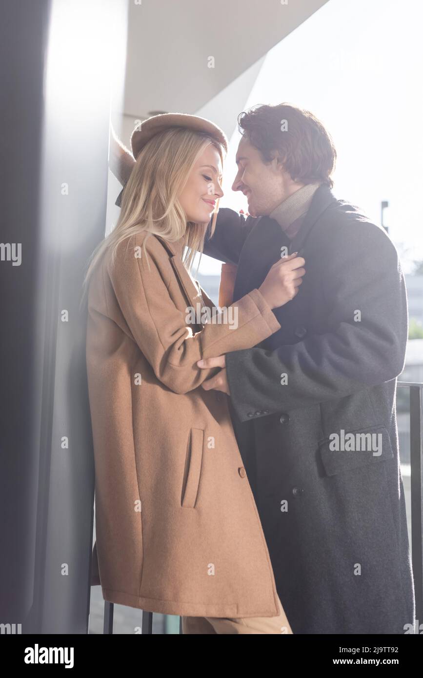 side view of young couple in autumn outfit standing face to face ...
