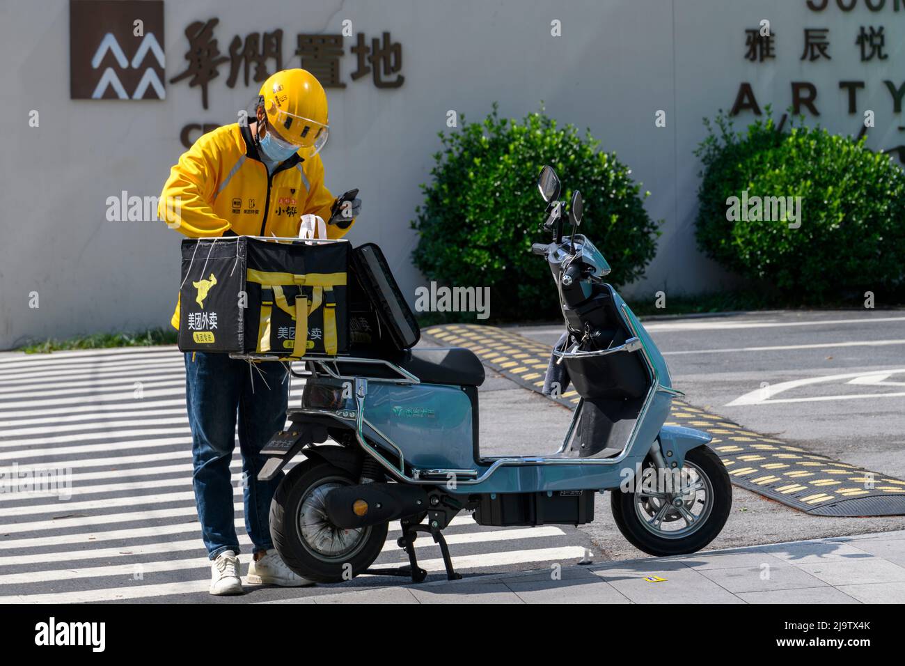 Meituan food delivery driver gets ready to make a food delivery on his ...
