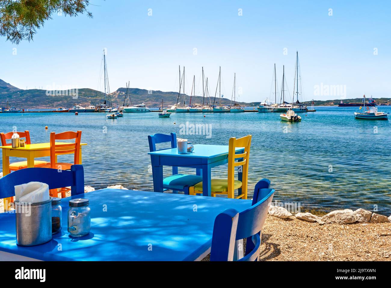 Colorful chairs and tables of Greek tavern by waterfront at day ...