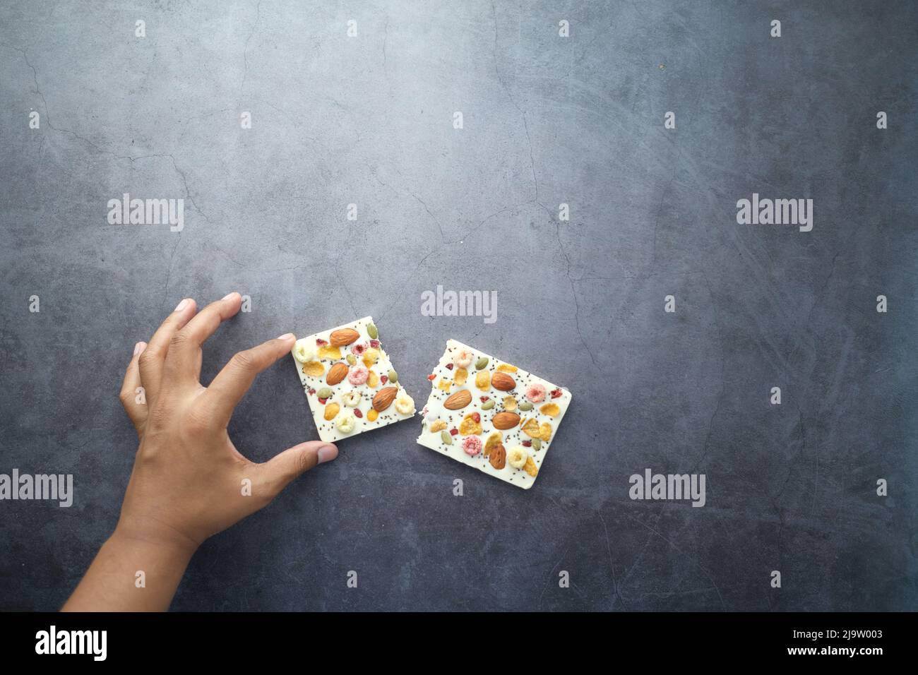 hand pick dark chocolate on black background Stock Photo - Alamy