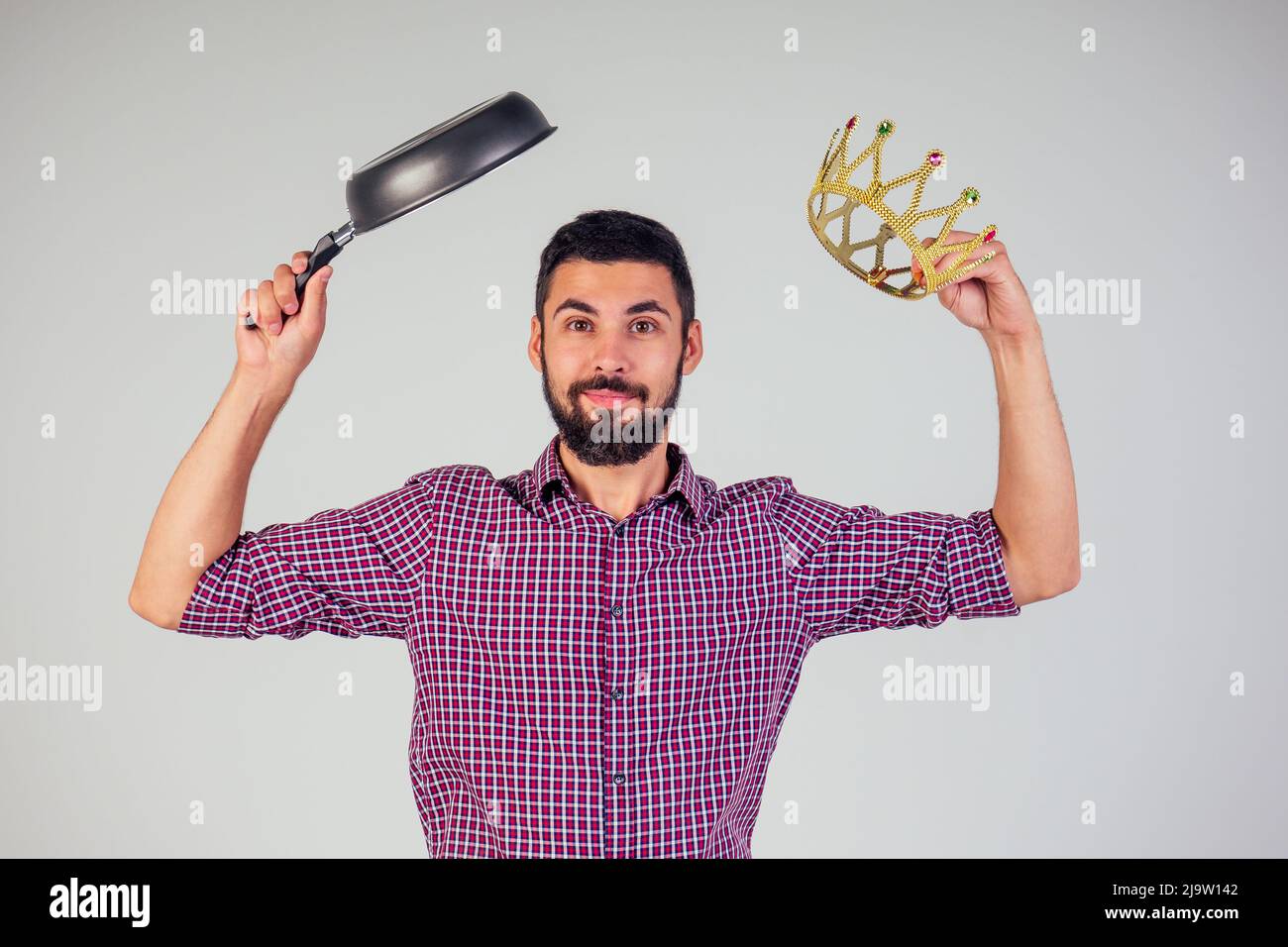 handsome man in a plaid red shirt and a golden crown on his head ...