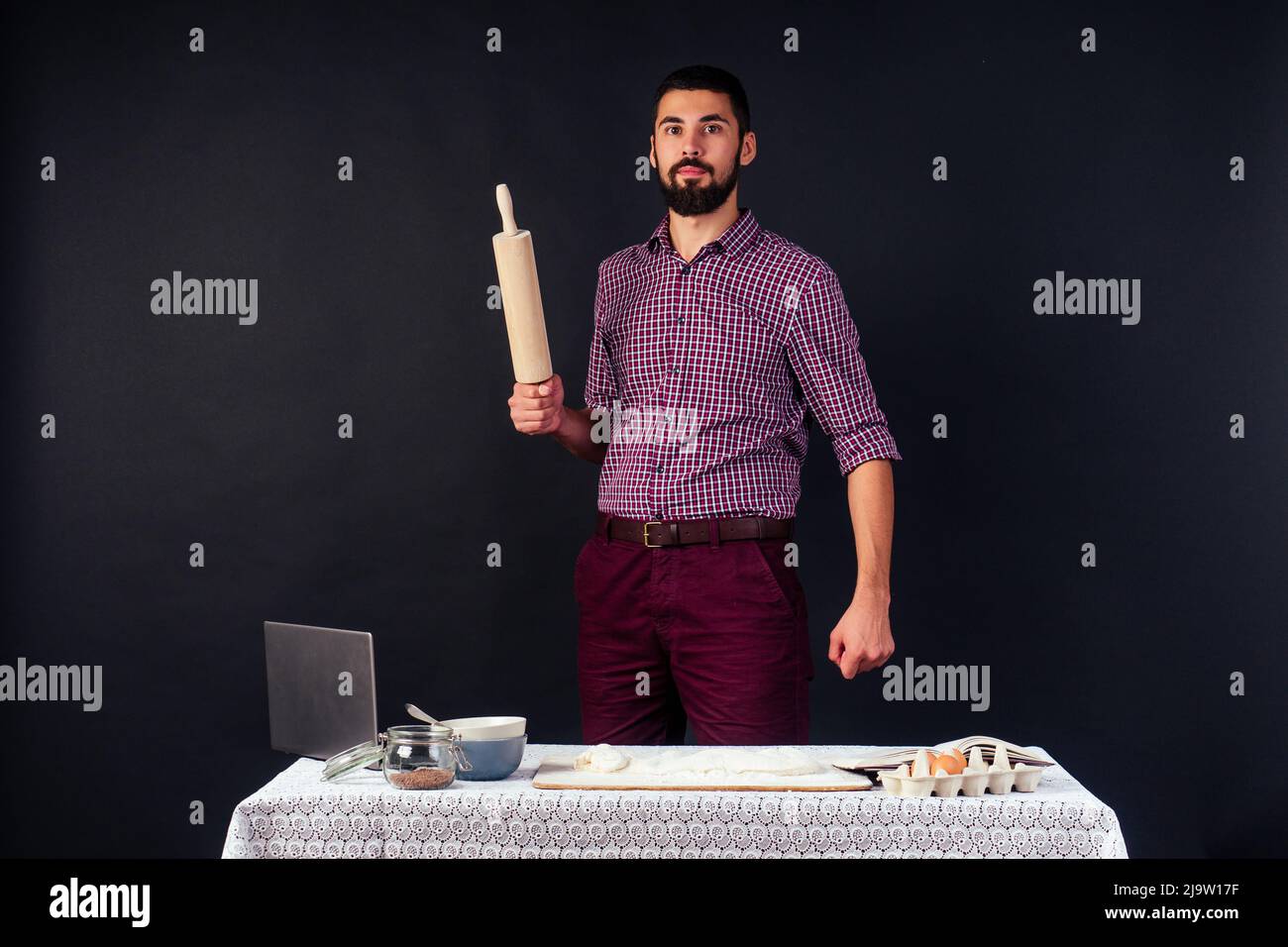 a handsome baker man with beard confectioner bakery with a golden crown ...