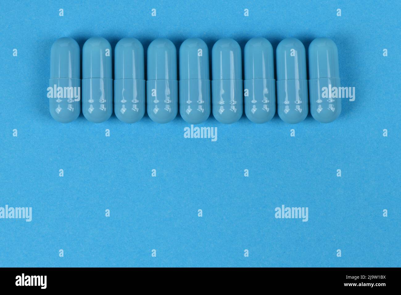 Blue medical capsules pill on blue background. High resolution photo ...