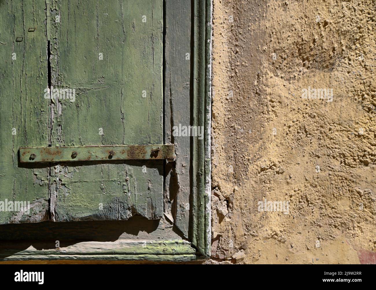 Old rural house antique olive green wooden window shutters with a rusty ...