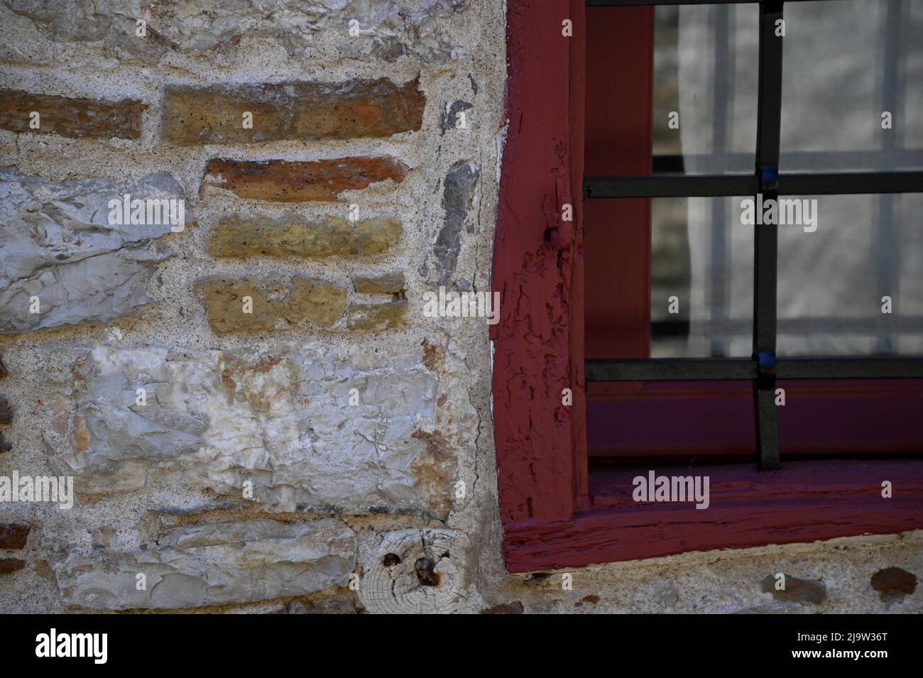 Old rural house garnet red wooden window with handcrafted wrought iron ...