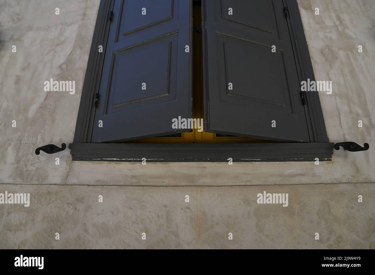 Classic charcoal grey wooden window shutters on a Venetian plaster ...