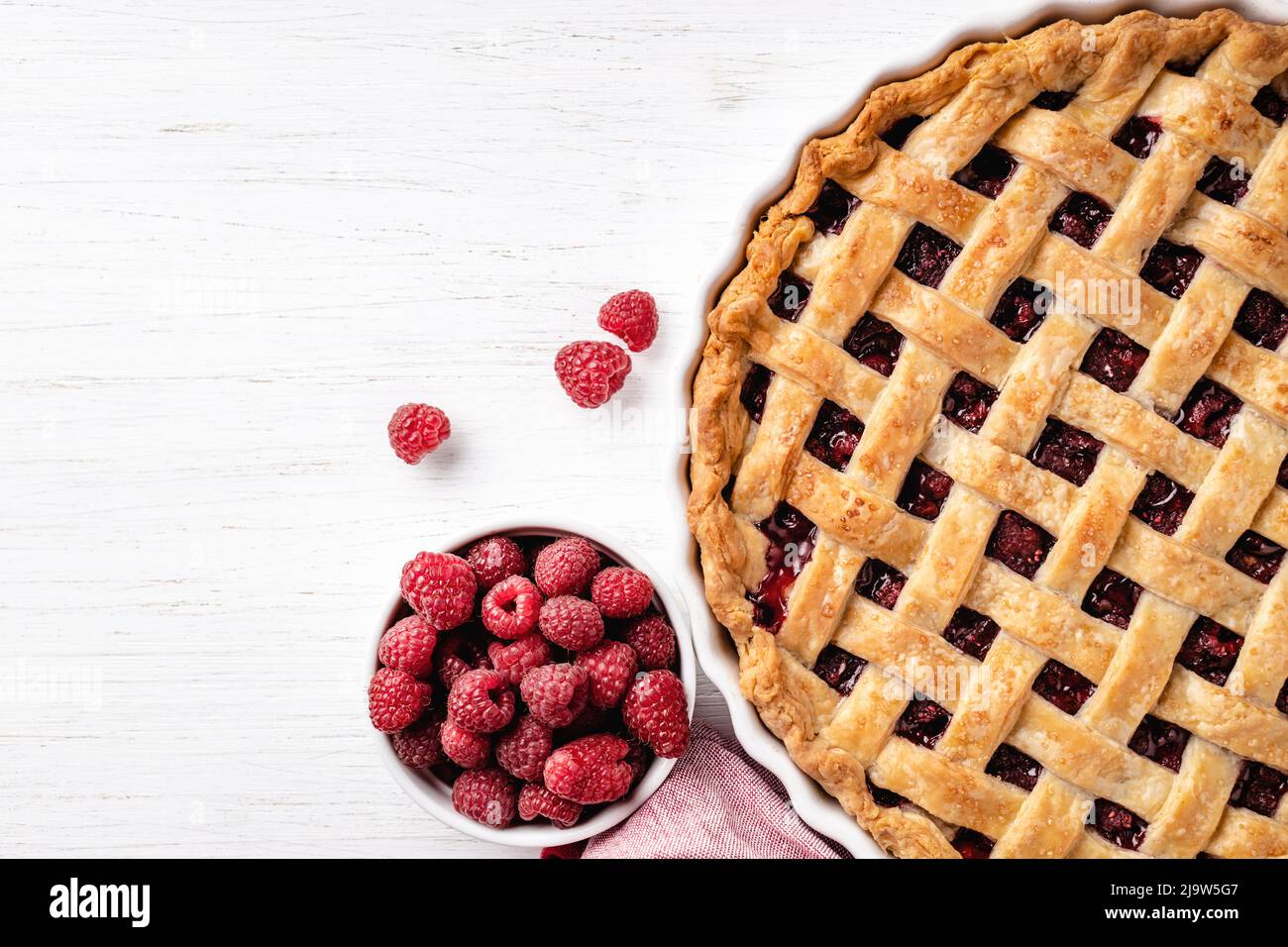Classic American raspberry pie in ceramic baking pan on white ...