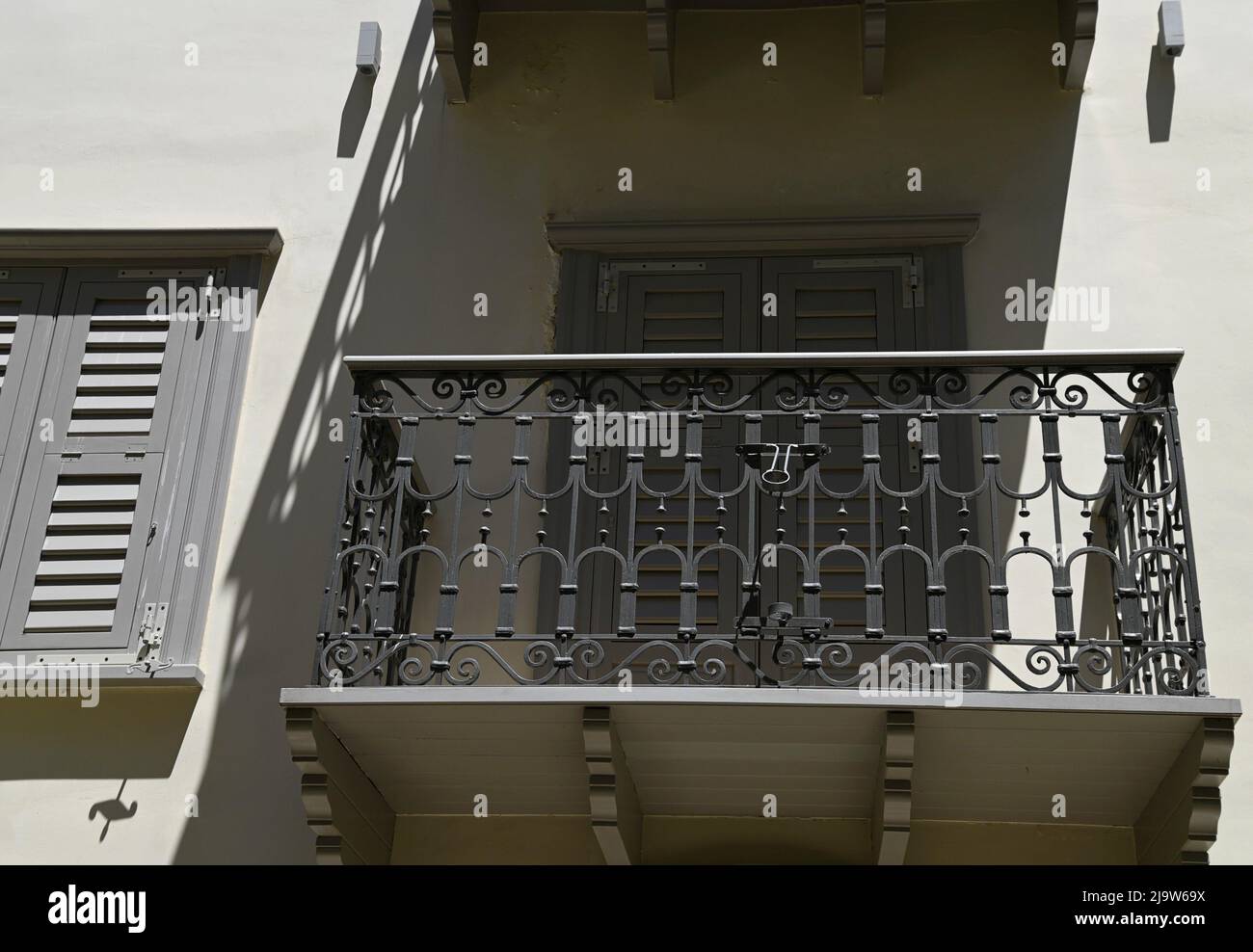 Old Neoclassical house facade with grey wooden window shutters and a ...