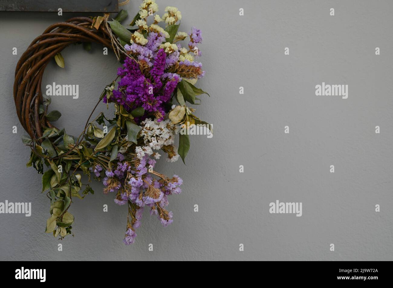 Handmade May wreath against a white stucco wall Stock Photo - Alamy