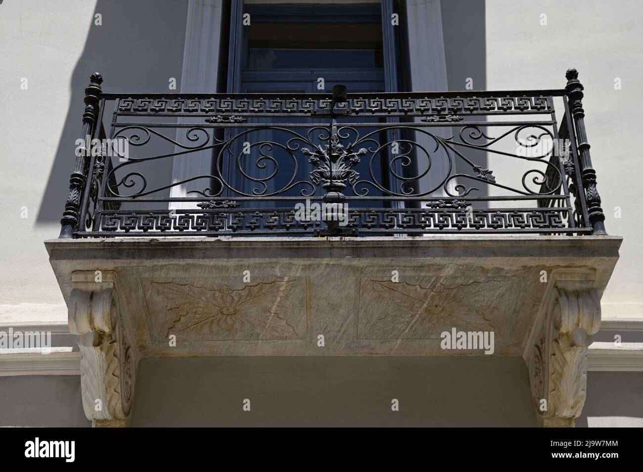 Neoclassical house facade with grey wooden window shutters and a ...