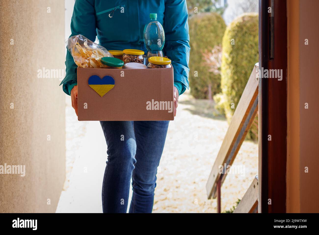 Humanitarian aid for Ukrainian refugees. Volunteer holding box with ...