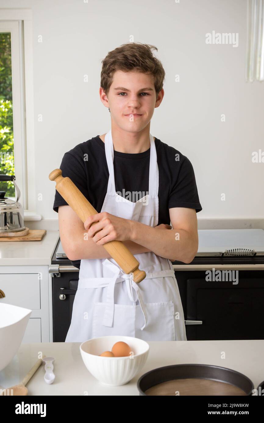A teenage boy in a domestic kitchen holding a rolling pin Stock Photo ...
