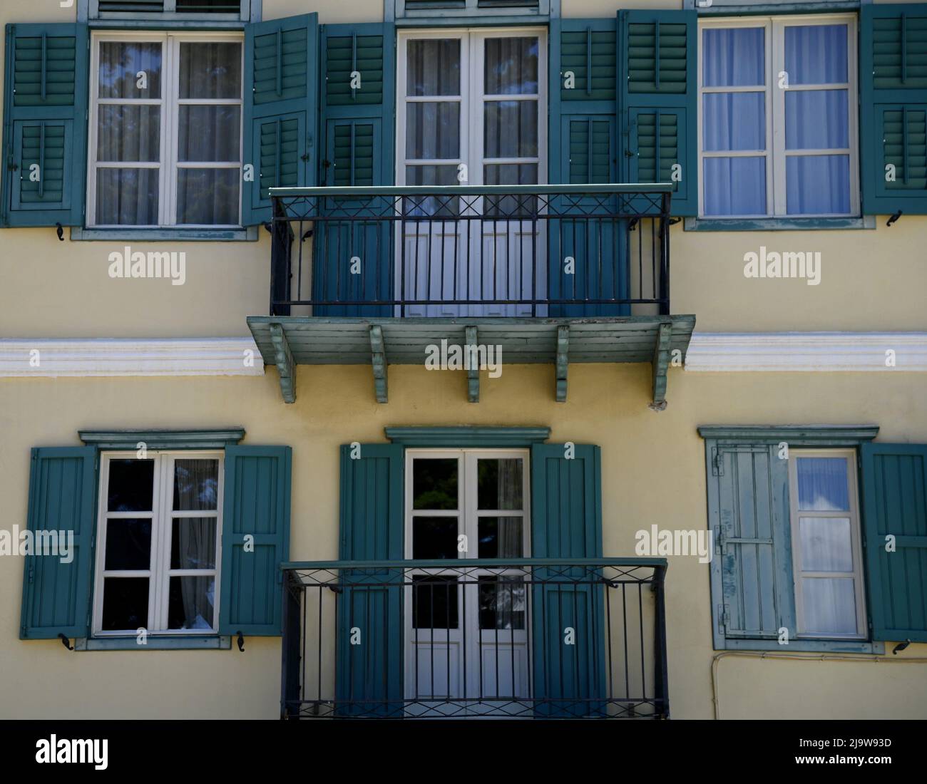 Neoclassical house facade with pine green wooden window shutters and a ...