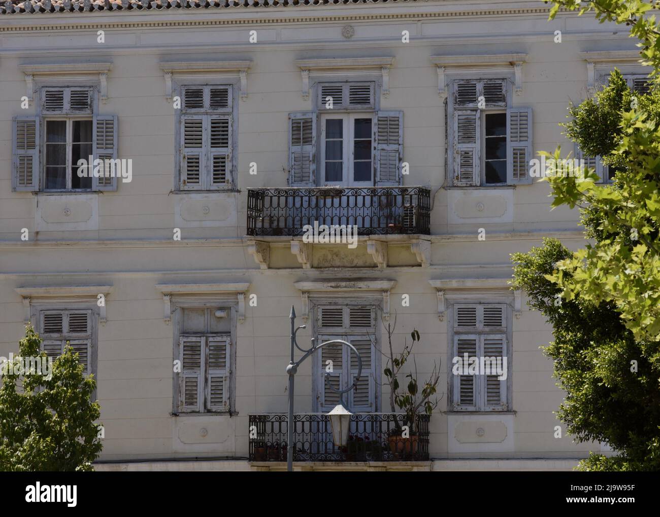 Old Neoclassical house with grey wooden shutters, balcony with a ...