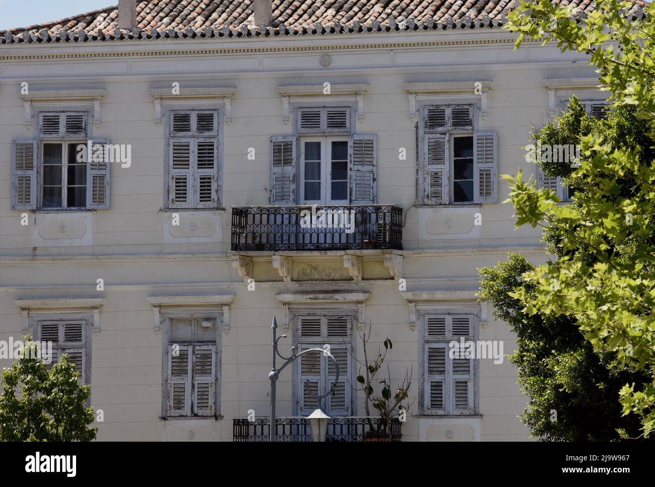 Old Neoclassical house with grey wooden shutters, balcony with a ...