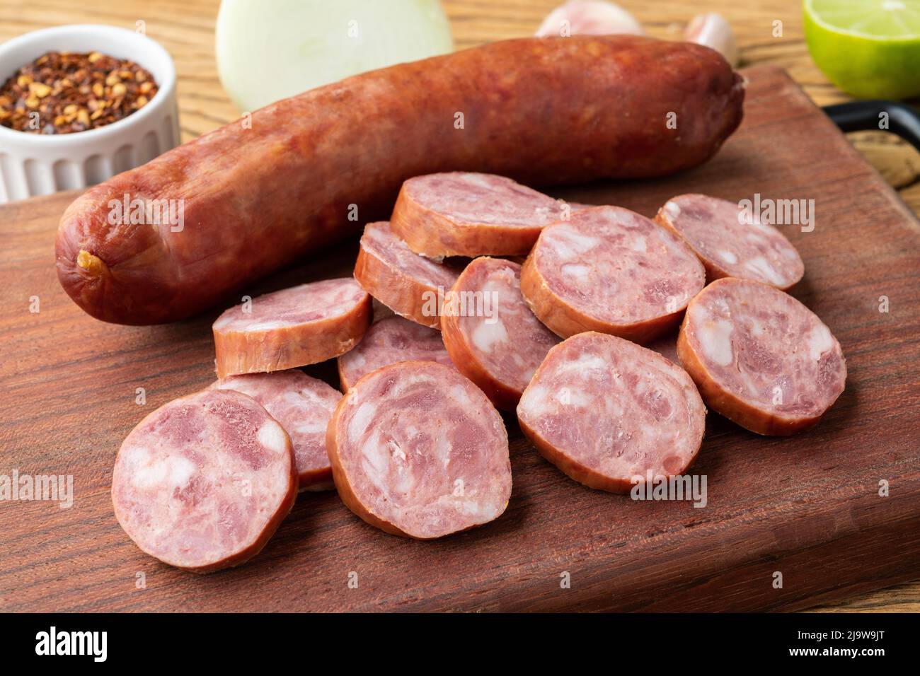 Calabrese pork sausage with slices over wooden board with seasonings ...