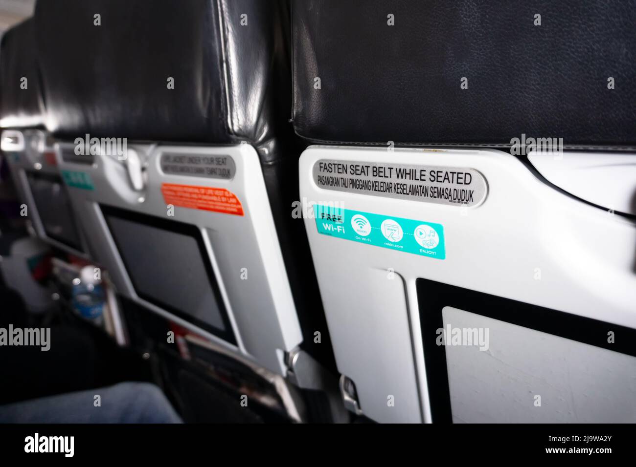 Seat belt safety sign on a commercial aircraft - Fasten seat belt while ...