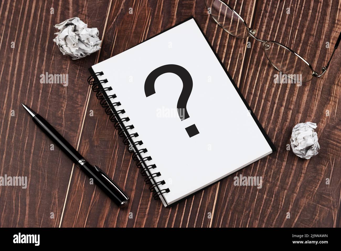 Question mark on note pad on top of office desk Stock Photo - Alamy