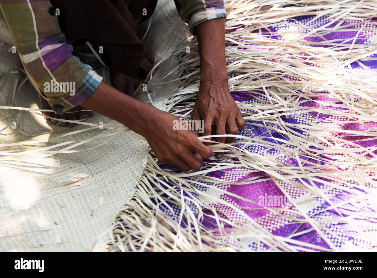 Woman weaving a traditional mat made from screw pines or Pandanus ...