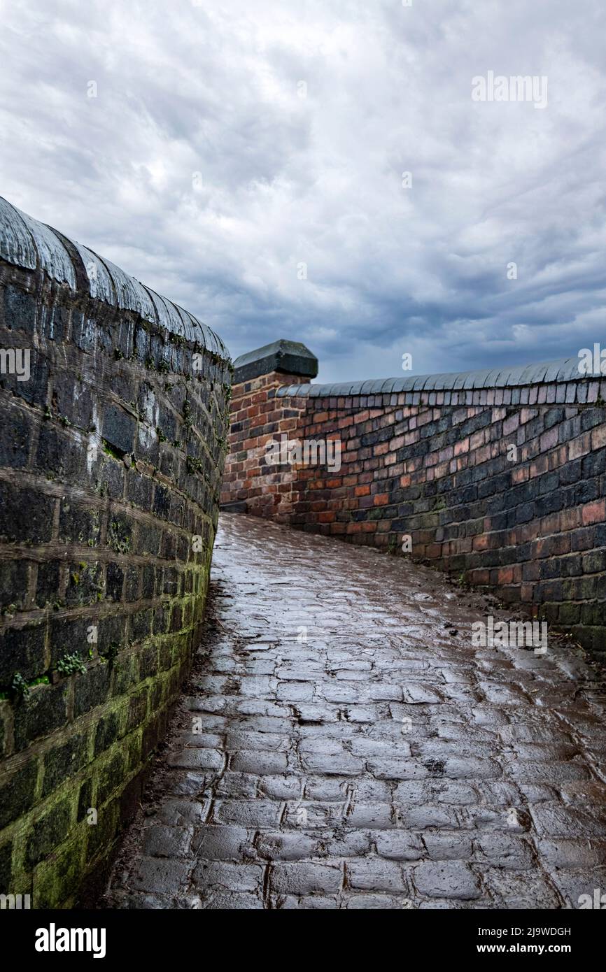 Wet cobbled footpath over canal Stock Photo - Alamy