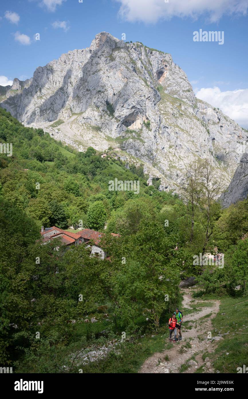 Walkers descend towards the Spanish mountain village of Bulnes, a ...