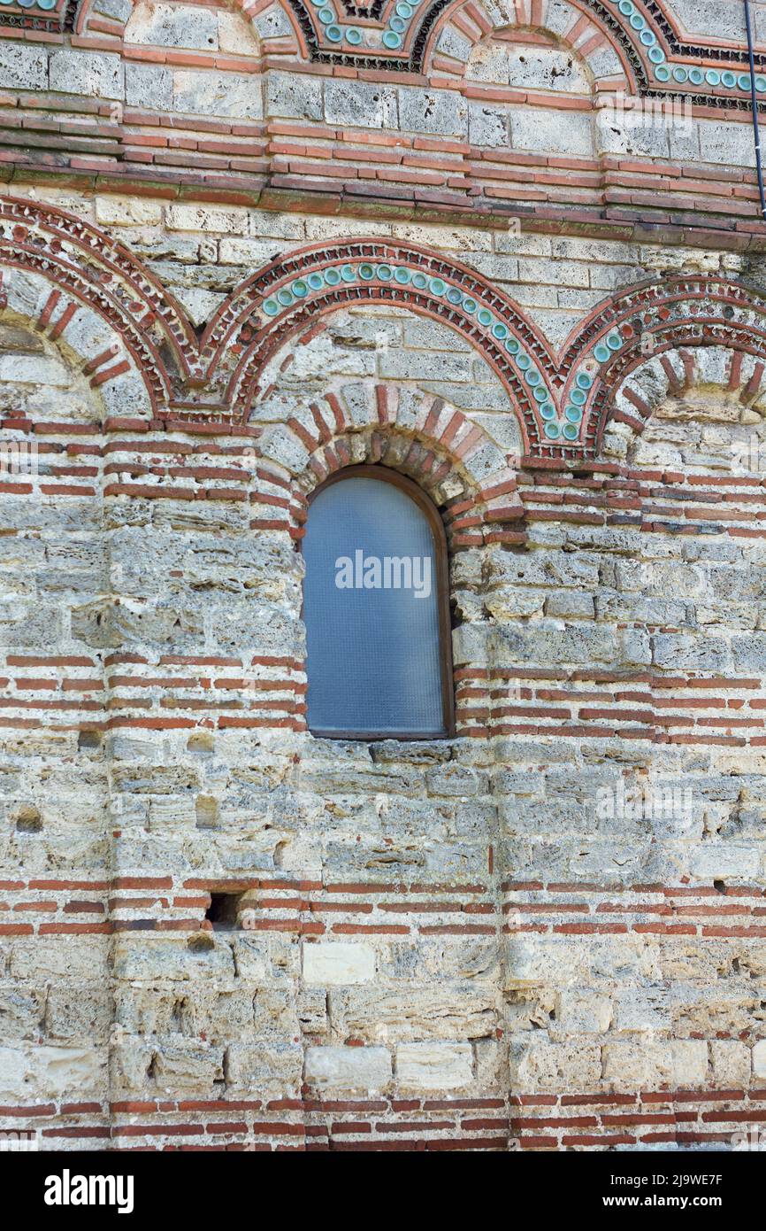 Facade of an old high wall with a window in fortress. Wall is made of ...