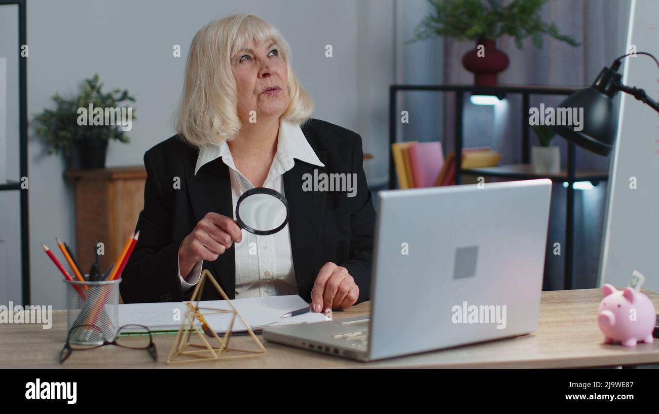 Mature person looks through magnifying hi-res stock photography and ...