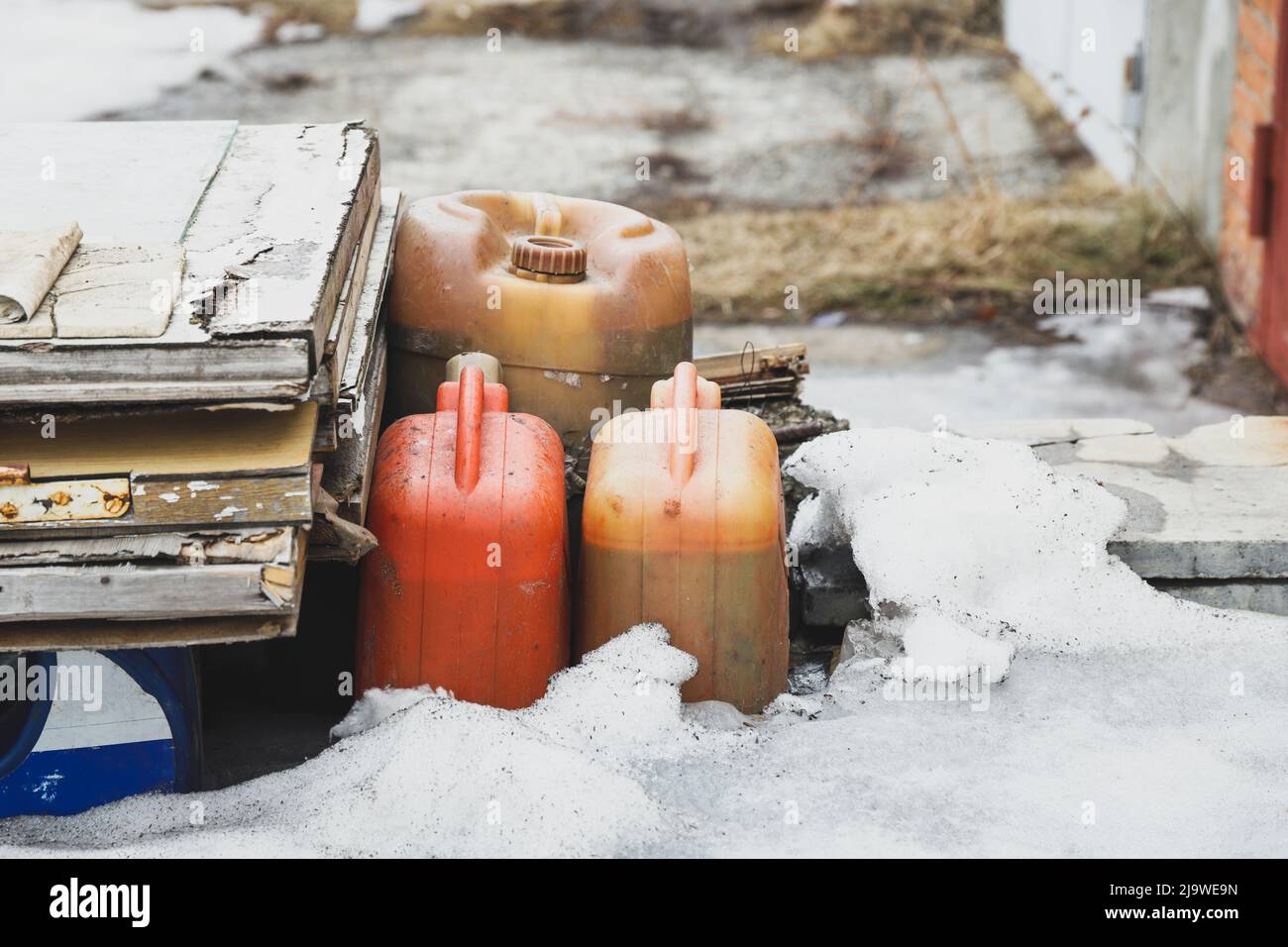 Old plastic canisters in the snow. Industrial background Stock Photo ...