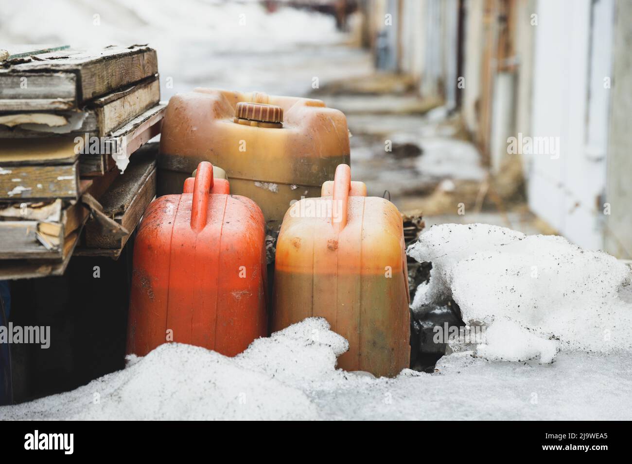 Old plastic canisters in the snow. Industrial background Stock Photo ...