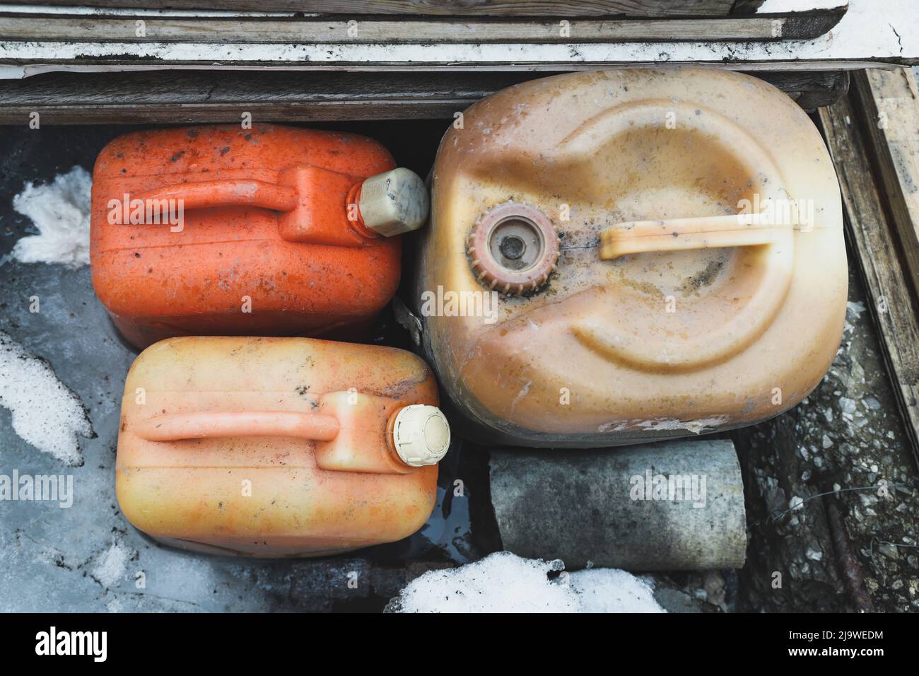 Old plastic canisters in the snow. Industrial background Stock Photo ...