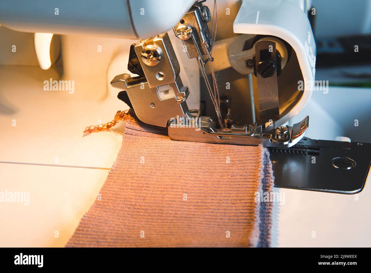 Sewing process on an overlock machine - macro shot. Selective focus ...