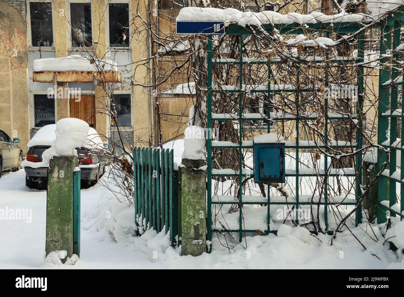 Entrance to the courtyard of a private house. Snowy winter. Outdoors ...
