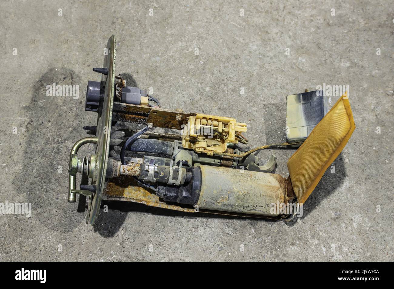 Old dirty rusty fuel pump on a gray background close-up. Car parts ...