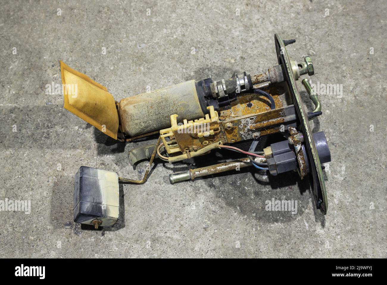 Old dirty rusty fuel pump on a gray background close-up. Car parts ...
