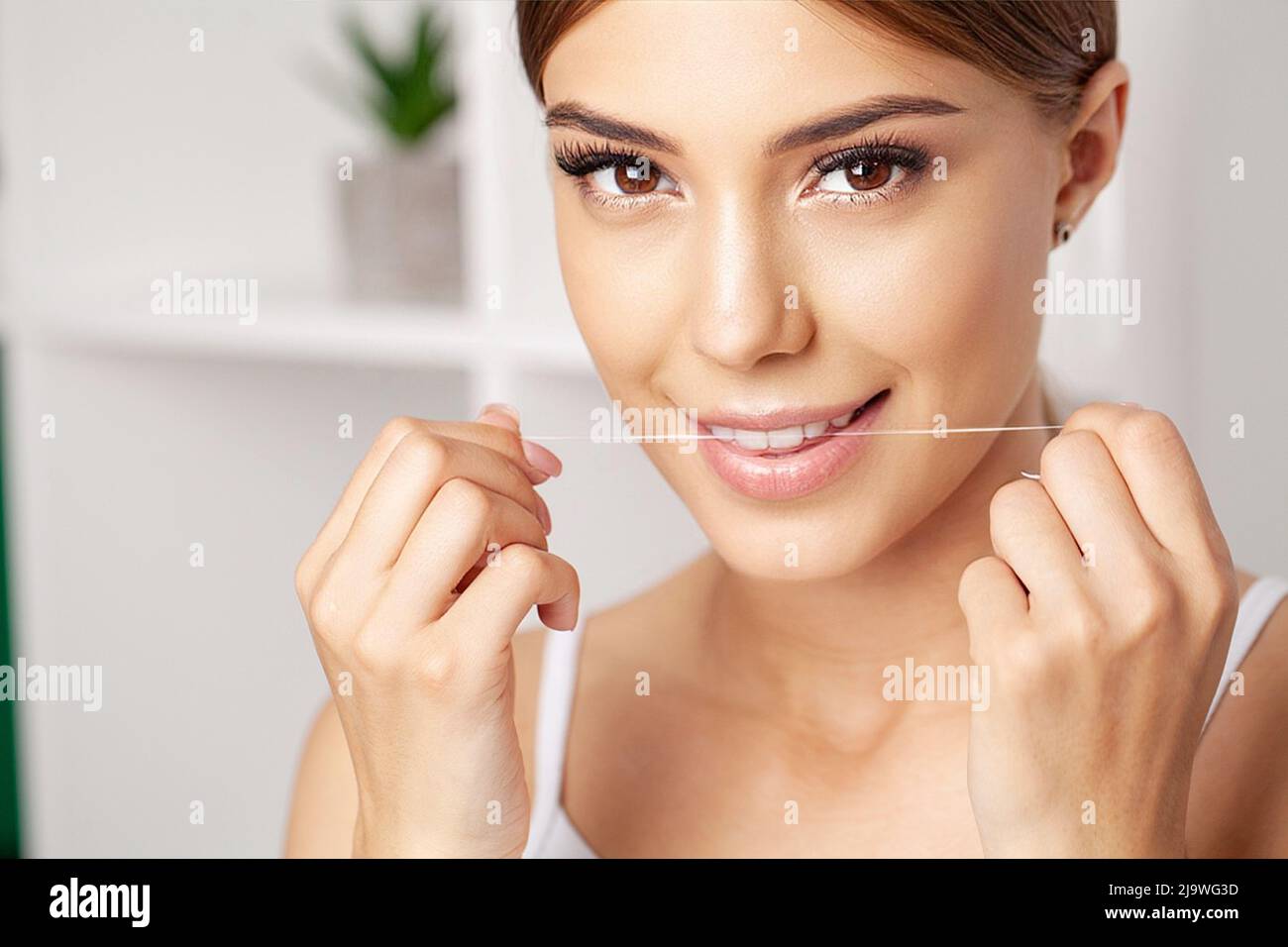 Cleaning teeth with dental floss, perfect healthy tooth Stock Photo - Alamy