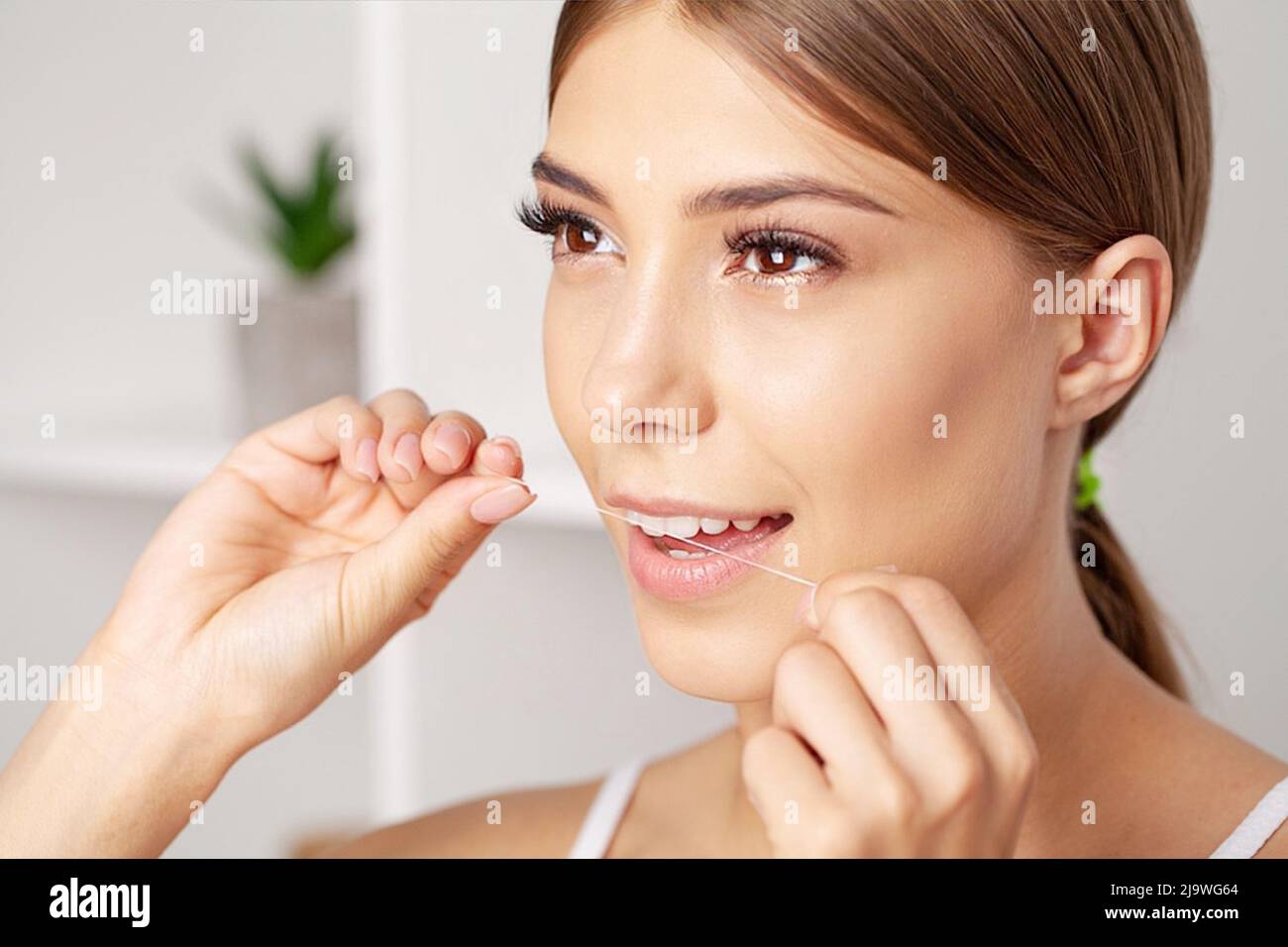 Cleaning teeth with dental floss, perfect healthy tooth Stock Photo - Alamy
